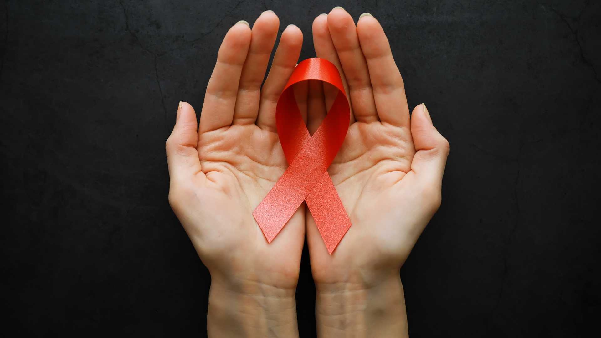 HIV-positive men kiss next to Trump's border for World AIDS Day